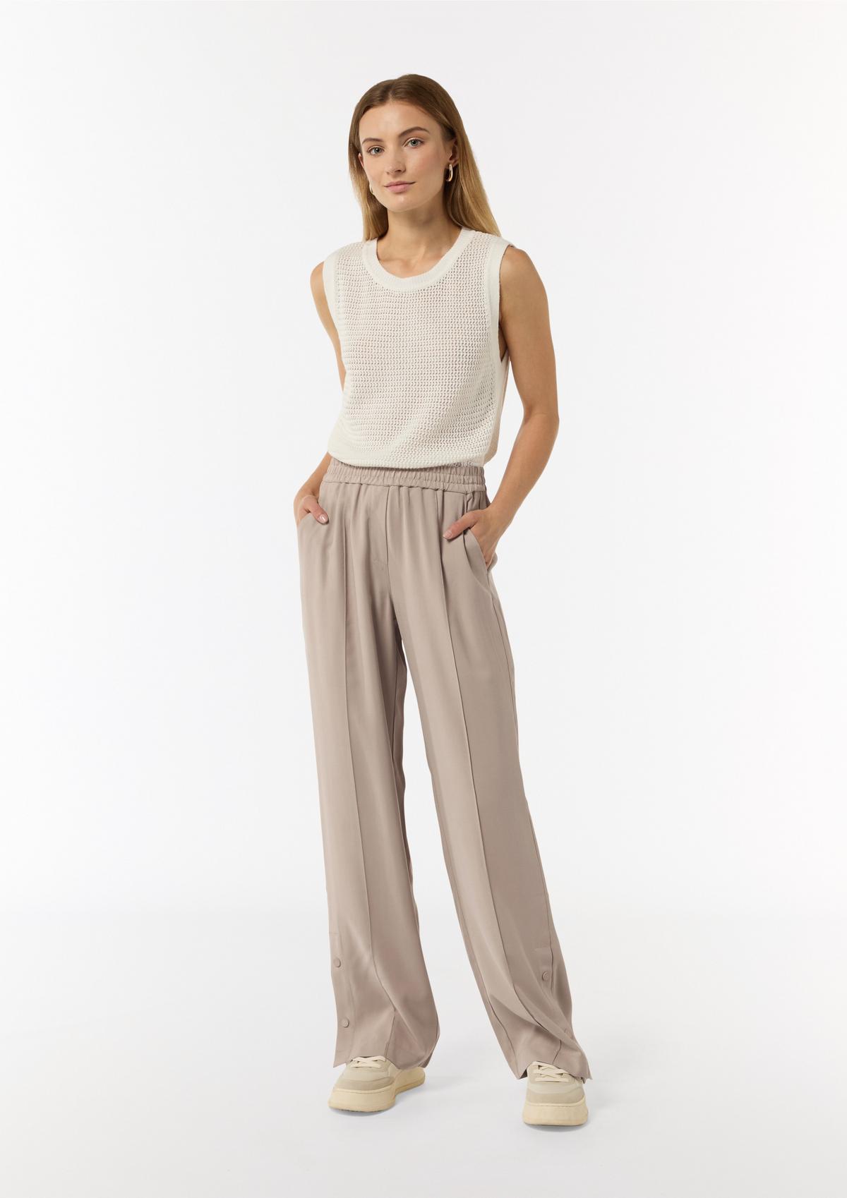 Tracksuit bottoms with a button-fastening hem - sand | Comma